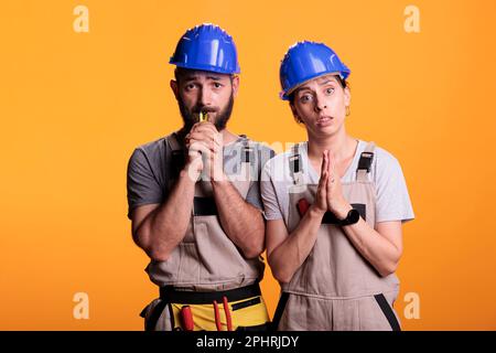 Team of contractors praying to work on building construction site ...