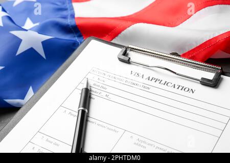 American flag, visa application form and passport on white wooden table ...