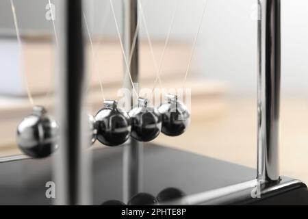 Newton's cradle on table, closeup. Physics law of energy conservation ...