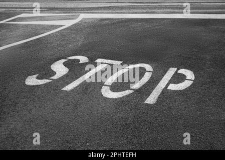 White sign STOP written on asphalt road Stock Photo - Alamy