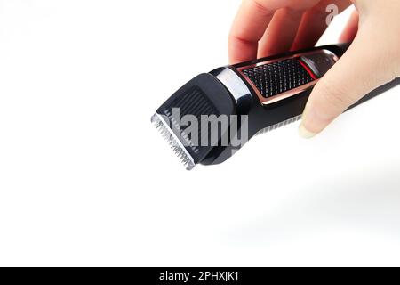 Defocus female hand holding electric clipper on white background ...