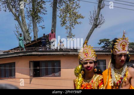 Kashmiri men watch from the rooftop of a building a procession marking Ram Navami festival in ...
