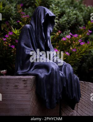 A menacing statue of the Grim Reaper, cloaked in a long, flowing robe ...