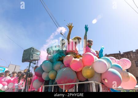A group of diverse people spreading color powder on each other at the ...