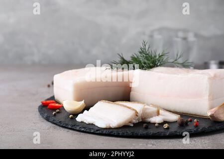 Pork fatback with spices served on grey table. Space for text Stock ...