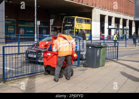 Postman sorting post from his four wheel trolley in Great Yarmouth ...