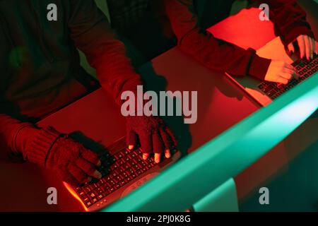 Anonymous people using computer and programming to break code. Cyber ...