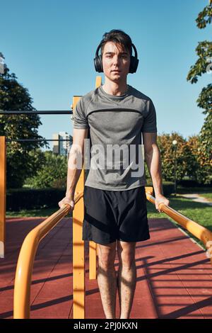 Young caucasian man doing parallel bars exercise outdoors Stock Photo - Alamy
