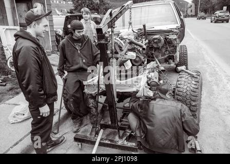 Shade tree street mechanics installing engine in old junker car in ...