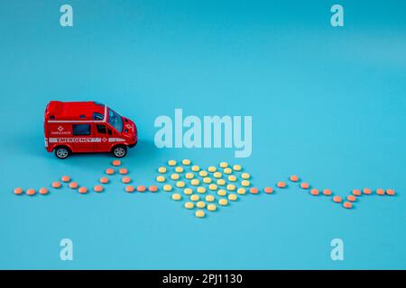 Drawing of a cardiogram from pills on a blue background and ambulance ...