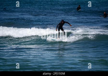 Practising surfing the waves on a quiet day at Yanchep Beach, Perth ...
