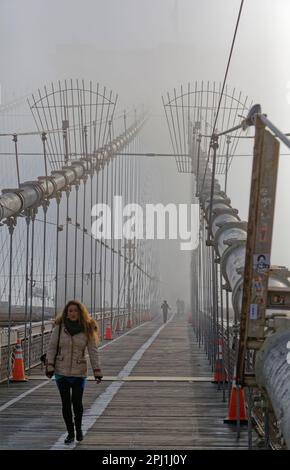 Brooklyn Bridge’s famous gothic towers are shrouded in a January fog ...