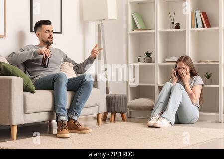 Bruised young woman talking by mobile phone at home. Domestic violence ...