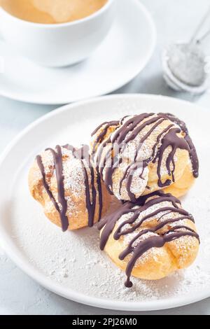 Homemade profiteroles and cup of coffee on wooden table Stock Photo - Alamy