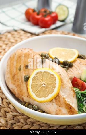 Delicious cooked chicken fillets with capers and salad on white ...