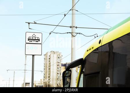 Modern streetcar near tram stop sign outdoors Stock Photo - Alamy