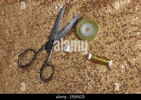 Gold Sequins on Fabric With Spool of Gold Metallic Thread and Thimble ...