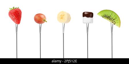 Forks with different tasty ingredients for fondue on white background ...