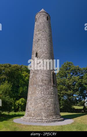 Ireland, County Laois, Timahoe Round Tower partly framed by a wall of a ...