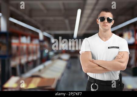 Young safeguard man wearing security uniform over yellow isolated ...