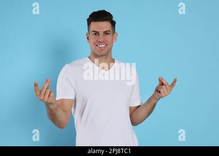 Man snapping his fingers on light grey background, closeup. Bad habit ...