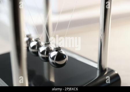 Newton's cradle on table, closeup. Physics law of energy conservation ...