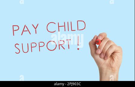 Man with marker and phrase PAY CHILD SUPPORT! on beige background ...