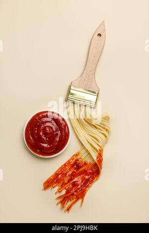 Brush painting with spaghetti dipped in ketchup on white background ...