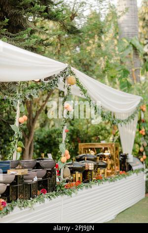 An outdoor buffet featuring a variety of vibrant colored dishes set up ...