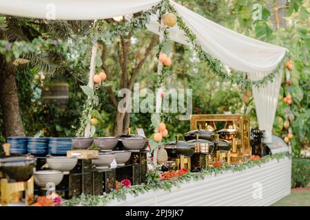 An outdoor buffet featuring a variety of vibrant colored dishes set up ...