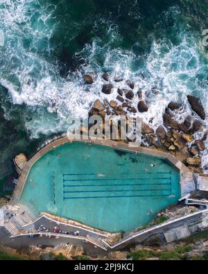 Mona Vale beach ocean rockpool on a winters day with green algae around ...