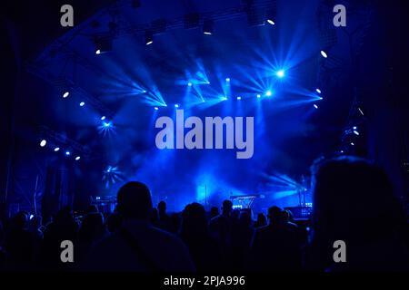 Colourful concert arena with a crowd silhouette against stage lights ...