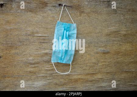 medical mask hanging on a hook an old wooden gate in Ukraine on the ...