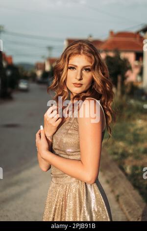 Beautiful ginger teen girl in glamorous golden dress. Ready for her ...