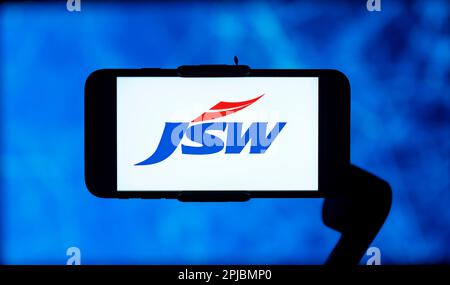 In this photo illustration, the JSW logo is seen displayed on a mobile ...