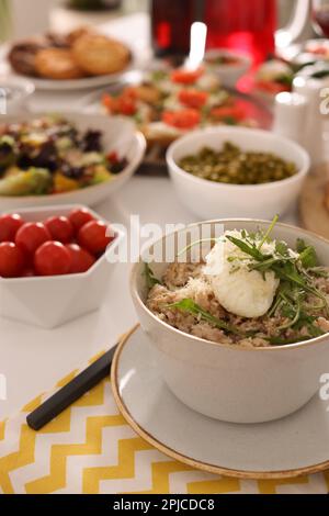 Bowl of oatmeal with poached egg, arugula and cheese served on buffet ...