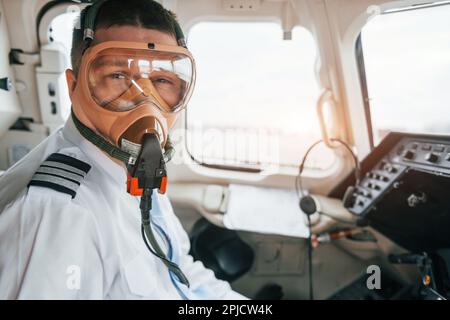 In oxygen mask. Pilot on the work in the passenger airplane. Preparing ...