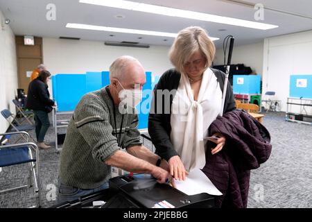 Patti Chang, who is blind, receives help from poll worker Bruce Mocking ...