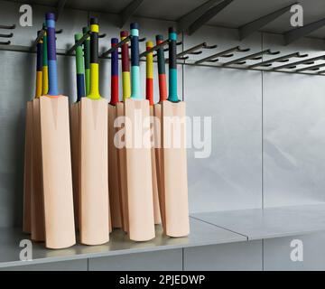 A collection of generic cricket bats with various colorful grips on ...