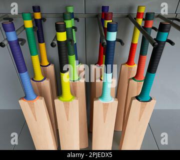 A collection of generic cricket bats with various colorful grips on ...