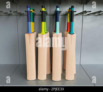 A collection of generic cricket bats with various colorful grips on ...