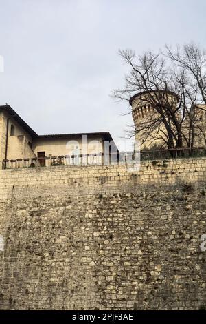 Outer boundary wall of a castle with trees and a cloudy sky as ...