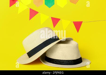 Straw hats with flags on yellow background. Festa Junina (June Festival ...