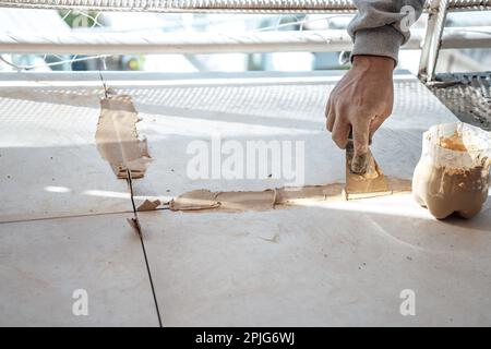 Mason passing the paste in the joint between tiles. I work in a ...