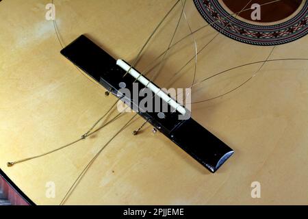 A broken wooden old classic guitar with damaged strings chords ...