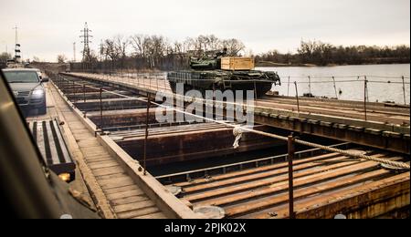 Ukrainian T-72B tank crossing a pontoon bridge rising to the front line ...
