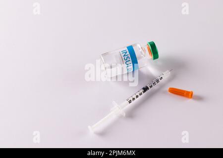 Insulin vial and uncapped syringe on white background with copy space ...