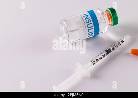 Insulin vial and uncapped syringe on white background with copy space ...