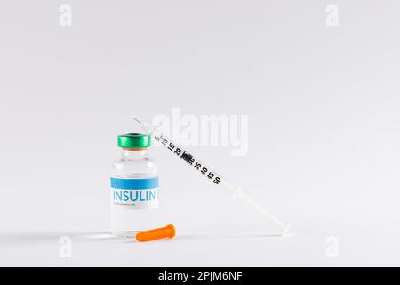 Insulin vial and uncapped syringe on white background with copy space ...