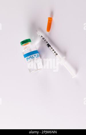 Insulin vial and uncapped syringe on white background with copy space ...